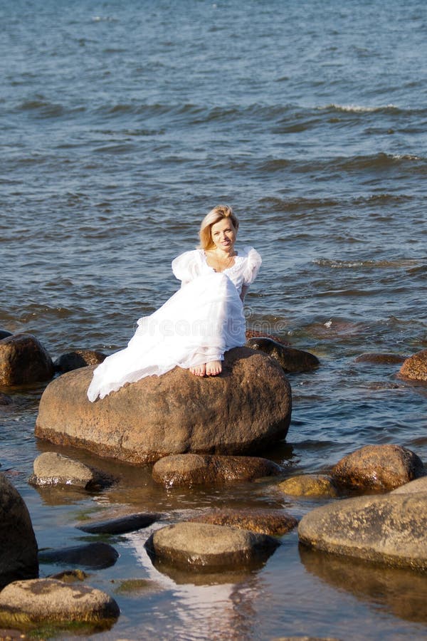 Woman Sitting on the Stone on the Seashore Stock Photo - Image of ...