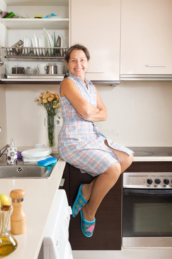 Woman Sitting on Table at Kitchen Stock Image - Image of adult, open ...
