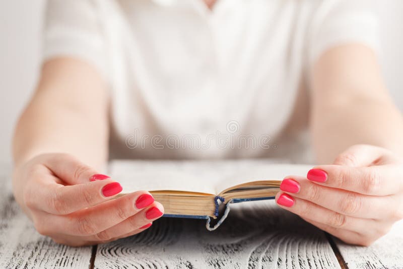 Woman Sitting at a Table Reading a Book Stock Photo - Image of table ...