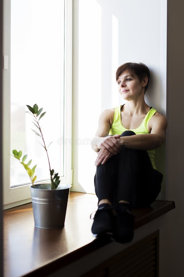 Woman Sitting on the Window and Looking into the Distance Stock Photo ...