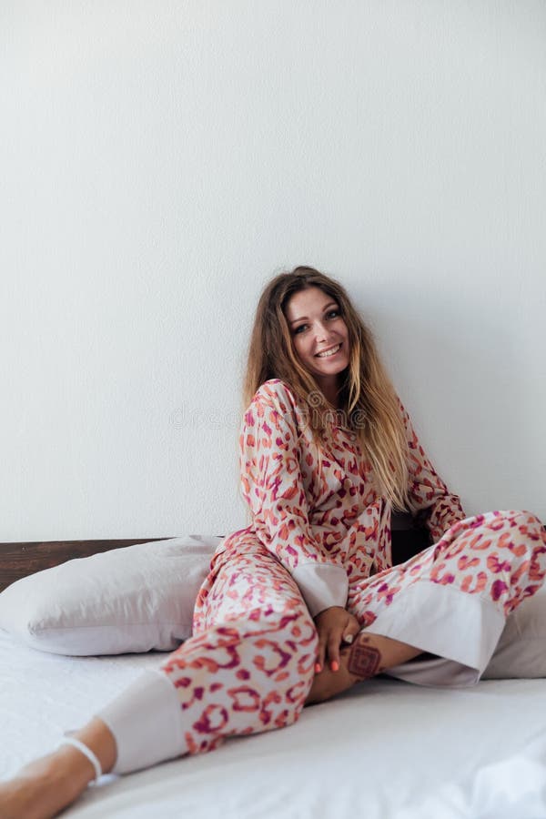 A Woman in Sleep Clothes Sits in Bed in the Bedroom Stock Photo - Image ...