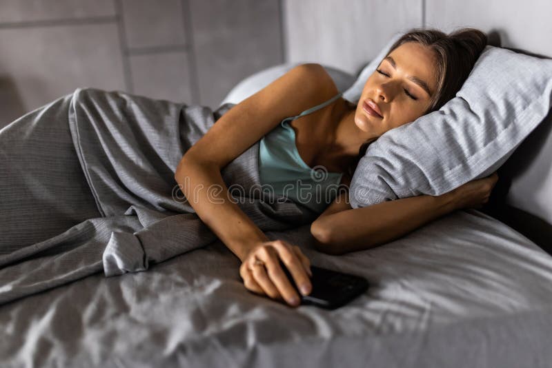 Young Woman Sleeping in Bed Being Woken by Mobile Phone Stock Image ...