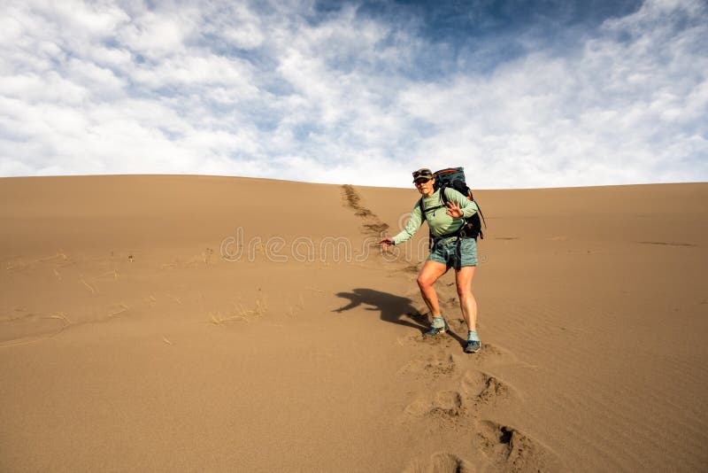 Woman Slides Down Steep Sand Dune Stock Image - Image of blue, nature ...