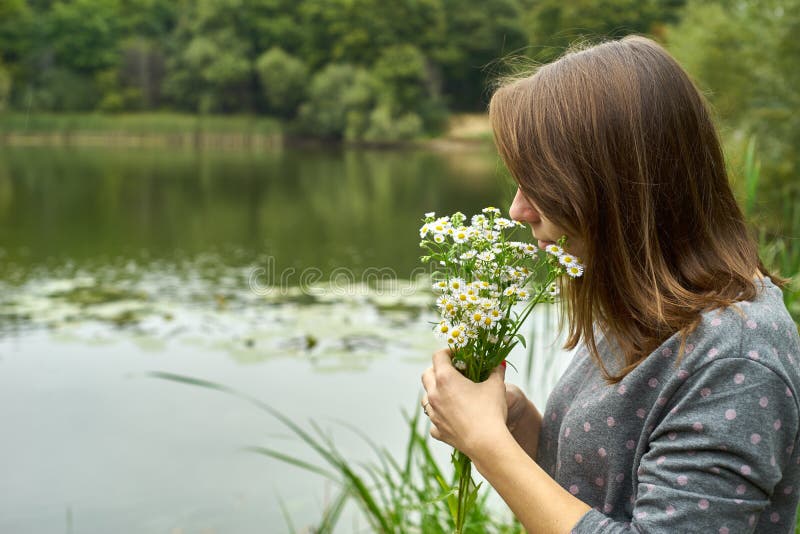 Woman smelling a daisy stock image. Image of girl, outdoors - 60857523