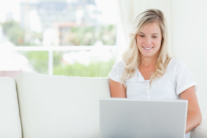 A Woman Smiling As she Looks at the Screen of the Laptop she is Stock ...