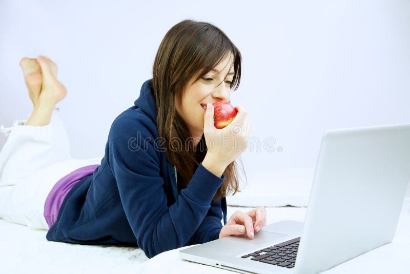 Woman Smiling Eats Apple in Front of Computer Stock Image - Image of ...