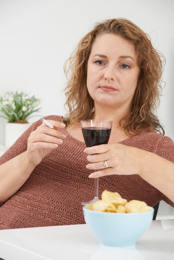 Woman Smoking Cigarette Whilst Drinking Wine and Eating Snacks Stock ...