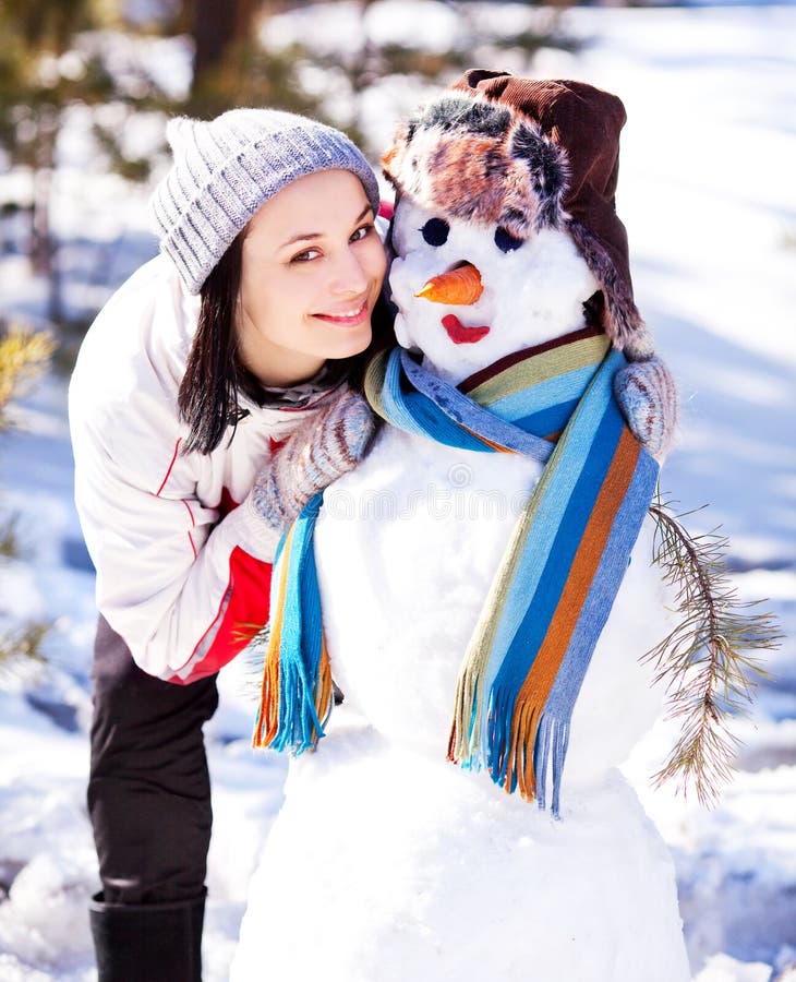 Woman with a snowman stock image. Image of mittens, snowdrift - 21993689