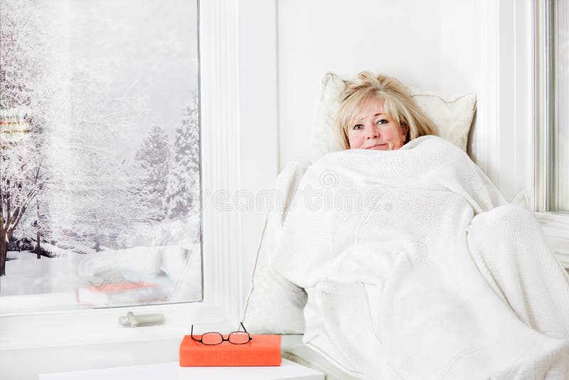 Woman Snuggling Under a Blanket Stock Photo - Image of female, looking ...