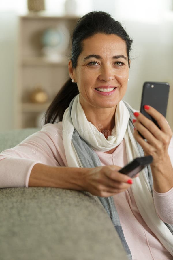 Woman on Sofa with Cellphone and Tv Control in Hands Stock Photo ...
