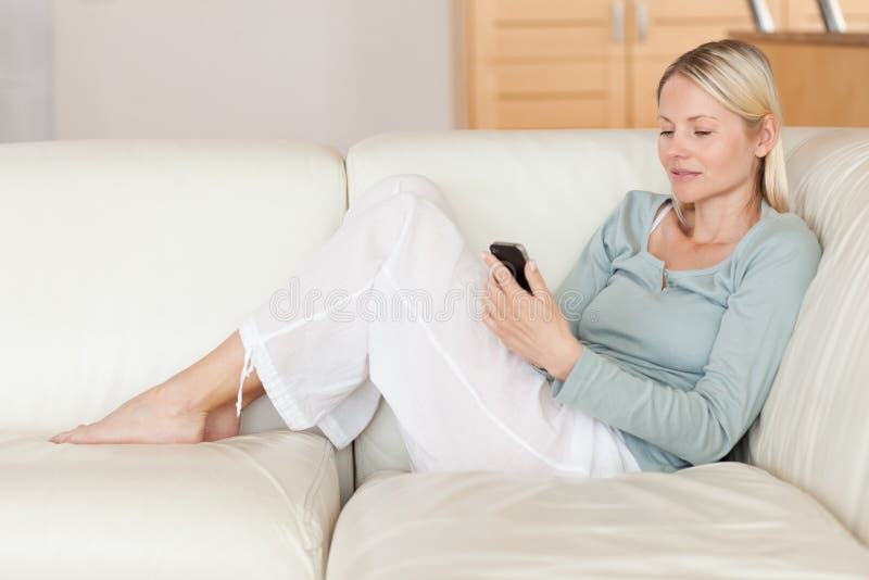 Woman on the Sofa Reading Text Message on Her Smartphone Stock Image ...
