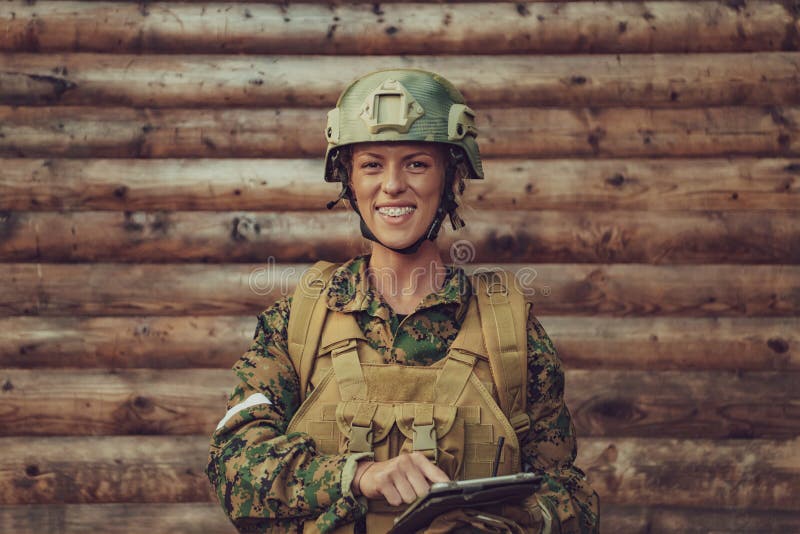 Woman Soldier Using Tablet Computer Against Old Wooden Wall in Camp ...