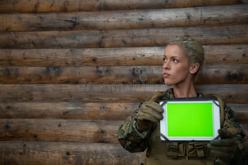 Woman Soldier Using Tablet Computer Against Old Wooden Wall in Camp ...