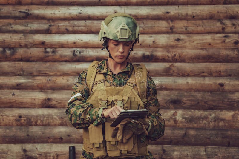 Woman Soldier Using Tablet Computer Against Old Wooden Wall in Camp ...
