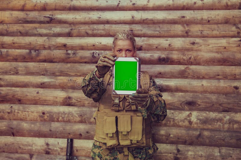 Woman Soldier Using Tablet Computer Against Old Wooden Wall in Camp ...