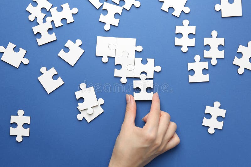 Woman Solving White Puzzle on Blue Background, Top View Stock Image ...