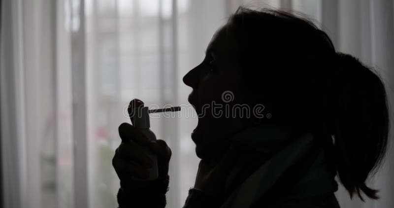 A Man With A Sore Throat Sprays A Medicinal Aerosol Spray Down His