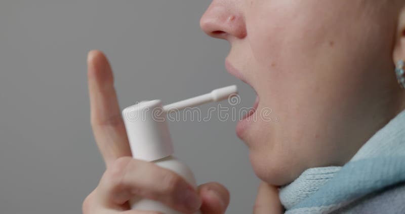 A Woman With A Sore Throat Sprays Medicine Aerosol Spray Down Her