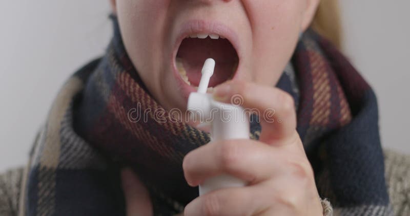 A Woman With A Sore Throat Sprays Medicine Aerosol Spray Down Her