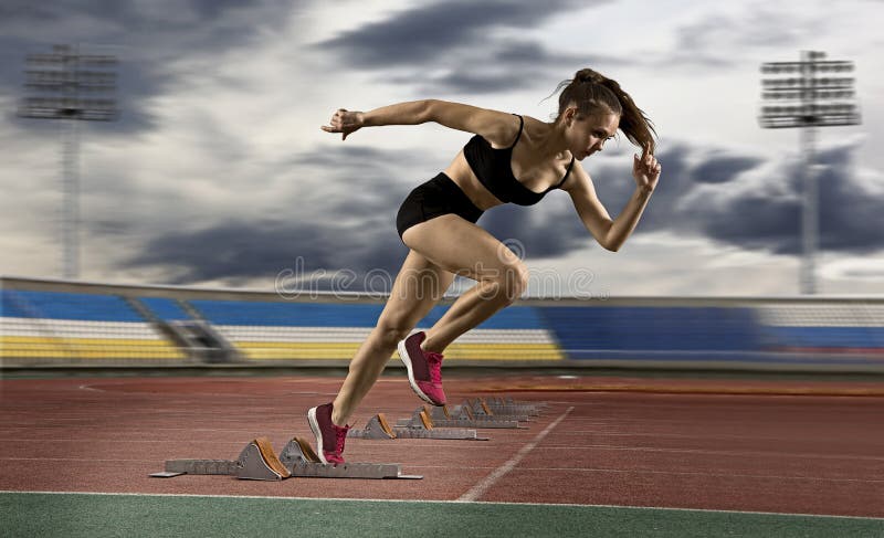 Woman Sprinter Leaving Starting Blocks on the Athletic Track Stock ...