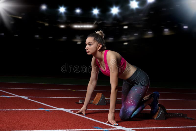 Woman Sprinter Leaving Starting Blocks on the Athletic Track. Exploding ...