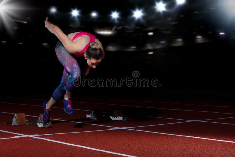 Woman Sprinter Leaving Starting Blocks on the Athletic Track. Exploding ...