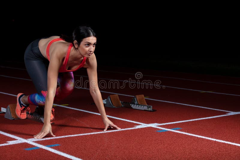 Woman Sprinter Leaving Starting Blocks on the Athletic Track. Exploding ...