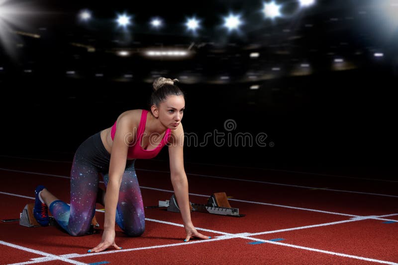 Woman Sprinter Leaving Starting Blocks on the Athletic Track. Exploding ...