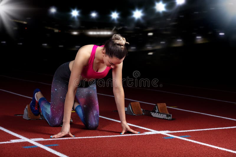 Woman Sprinter Leaving Starting Blocks on the Athletic Track. Exploding ...