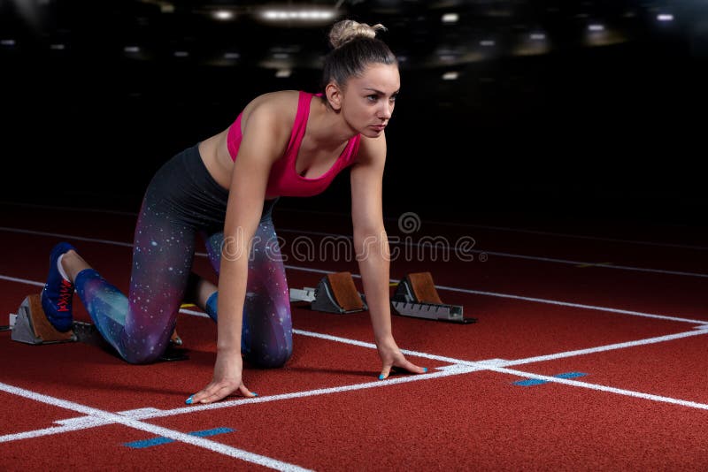 Woman Sprinter Leaving Starting Blocks on the Athletic Track. Exploding ...