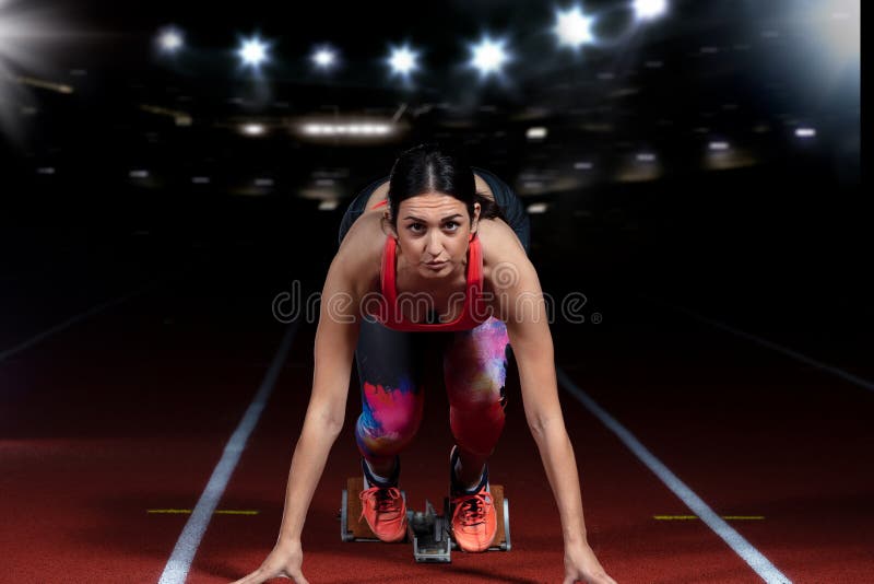 Woman Sprinter Leaving Starting Blocks on the Athletic Track. Exploding ...