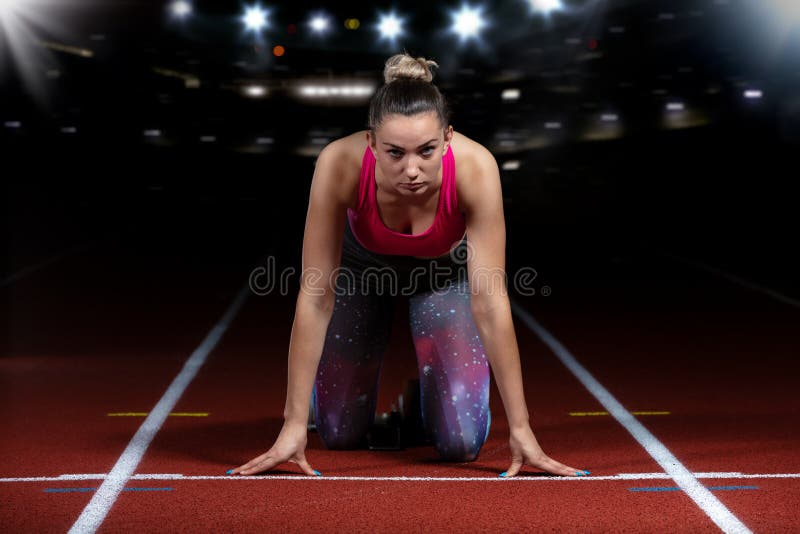 Woman Sprinter Leaving Starting Blocks on the Athletic Track. Exploding ...