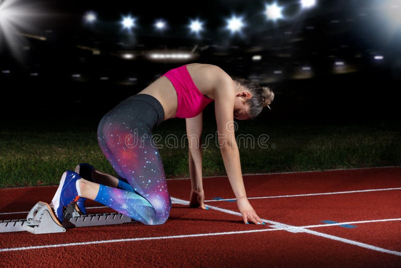 Woman Sprinter Leaving Starting Blocks on the Athletic Track. Exploding ...