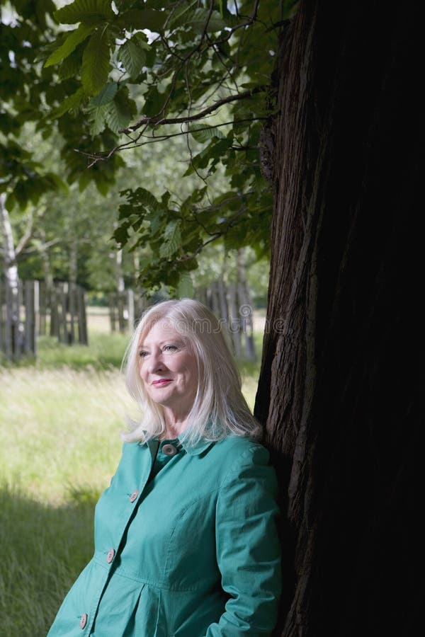 Woman Standing Beneath Tree Stock Photo - Image of country, pensioner ...