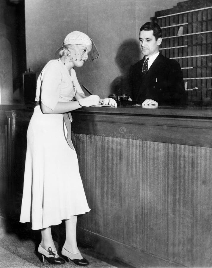Woman Standing at the Counter of a Hotel Where she is Checking in Stock ...