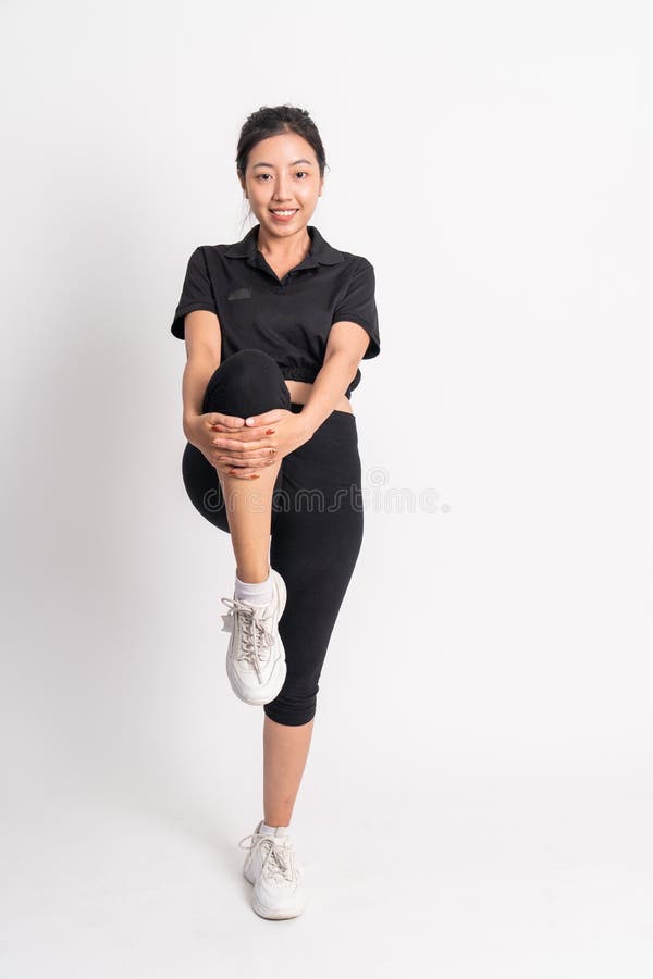 Woman Standing Doing Leg Stretch by Lifting and Holding Legs Stock ...