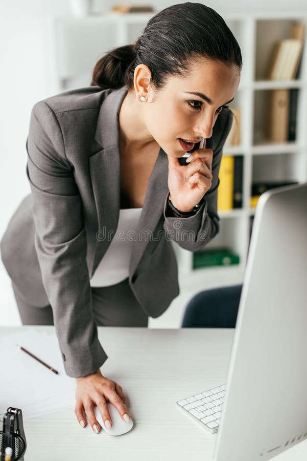 Woman Standing in Front of Computer and Talking on Smartphone Stock ...