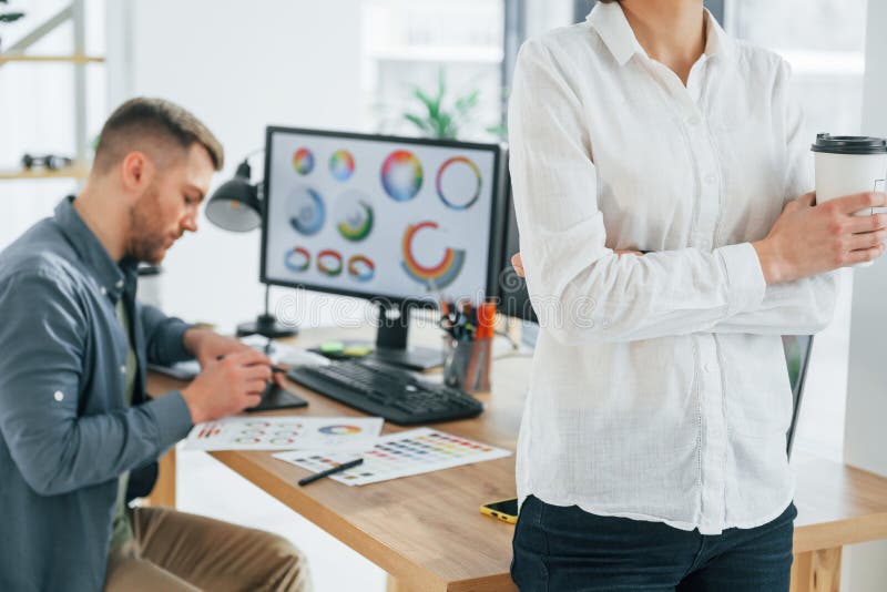 Woman Standing in Front of Man that Sitting by the Table. Two Designers ...