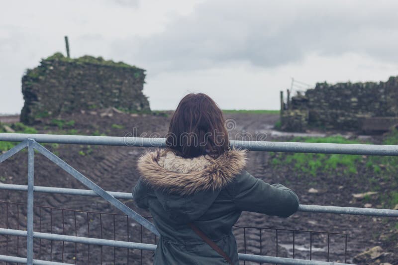 Woman Standing by Gate in Countryside Stock Photo - Image of parka ...