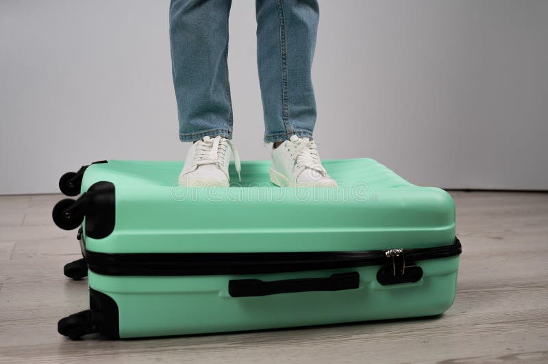 Woman Standing with Her Feet on a Suitcase. Stock Image - Image of full ...