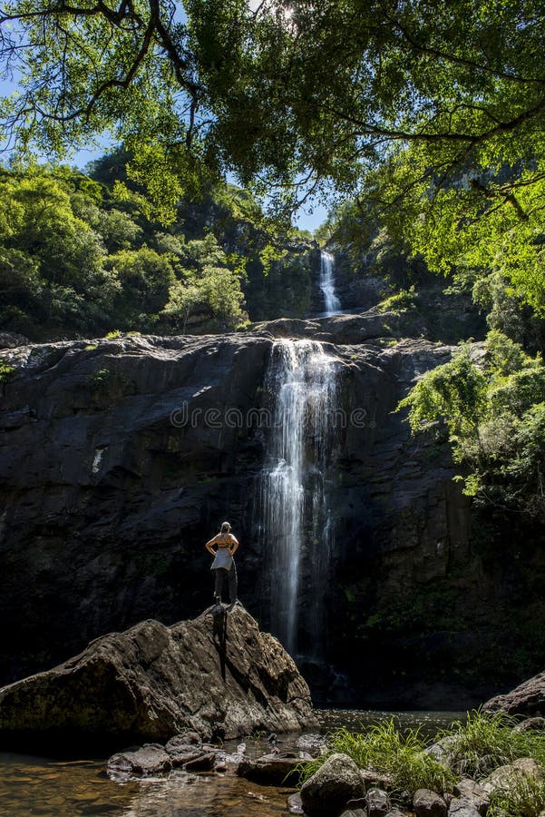 Woman Standing on a Rock Looking at a Waterfall in the Forest Stock ...