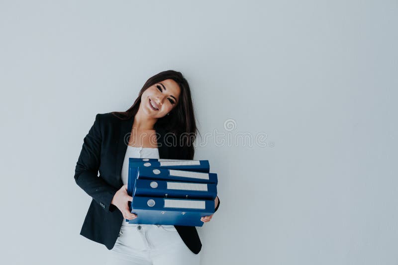 A Woman Standing with a Stack of Blue Folders in the Office Stock Photo ...