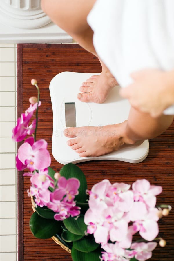 Woman stepping on scale stock image. Image of wellbeing - 12385407