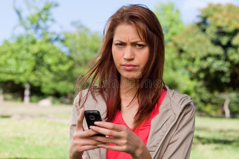 Woman with a Stern Expression on Her Face while Holding a Phone Stock ...