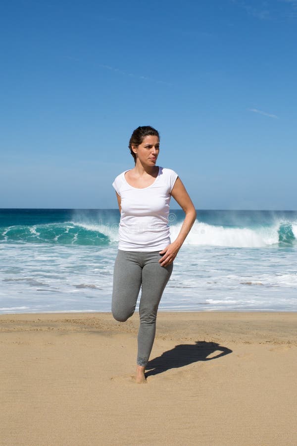 Woman Stretches Leg on Beach Stock Photo - Image of fitness, athletes ...