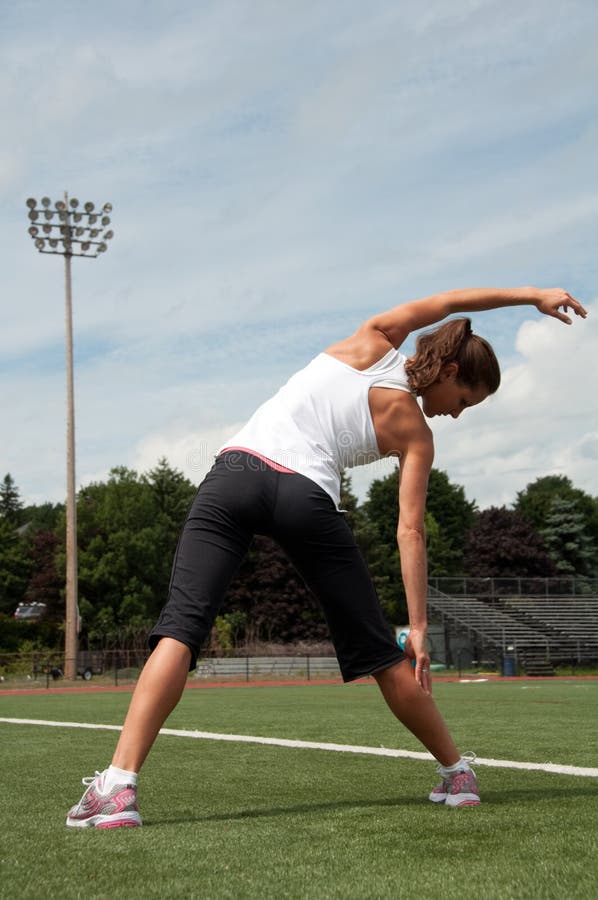 Woman Stretching on Playing Field Stock Photo - Image of warming, yoga ...