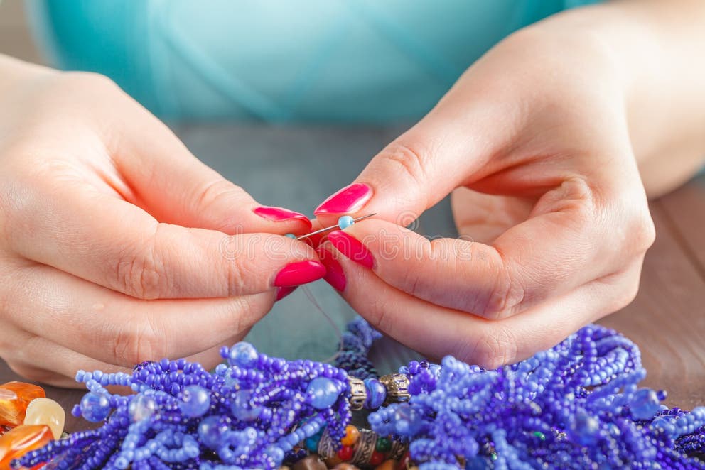 Woman stringing beads stock photo. Image of blue, stringing - 65546174