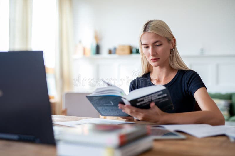 Woman Student Reading Book Sitting at Table Stock Photo - Image of book ...