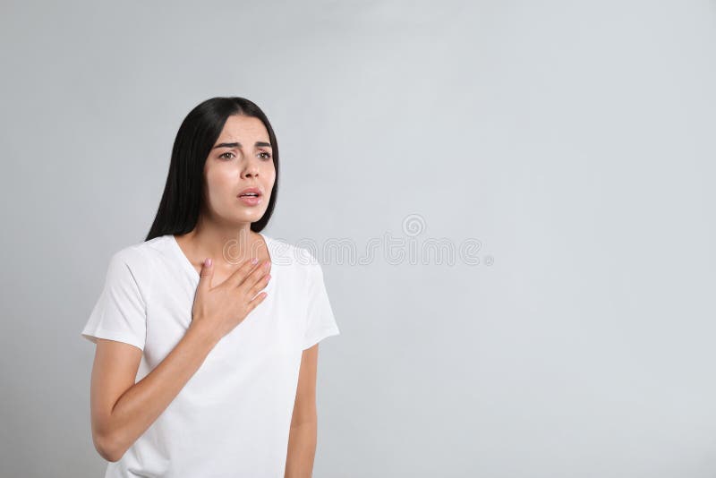 Young Woman Suffering from Breathing Problem on Light Background. Space ...