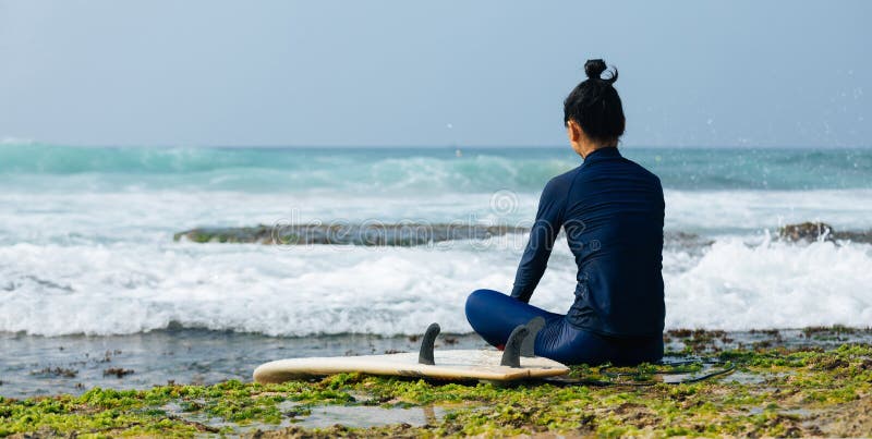 Woman surfer sit on reef stock photo. Image of exercise - 133532424